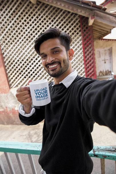 Placeit - Selfie Mockup of a Smiling Man Holding a Coffee Mug in the Street
