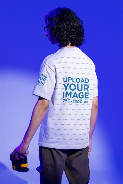 Placeit - Back-View Mockup of a Man Posing at a Studio While Wearing a Tee