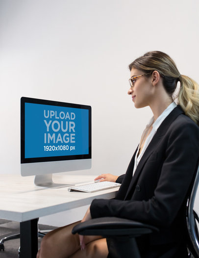 Placeit - Woman Working with an iMac Mockup at the Office