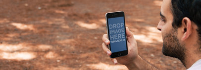 Placeit - Mockup of a Bearded Man Using iPhone 6 Outdoors