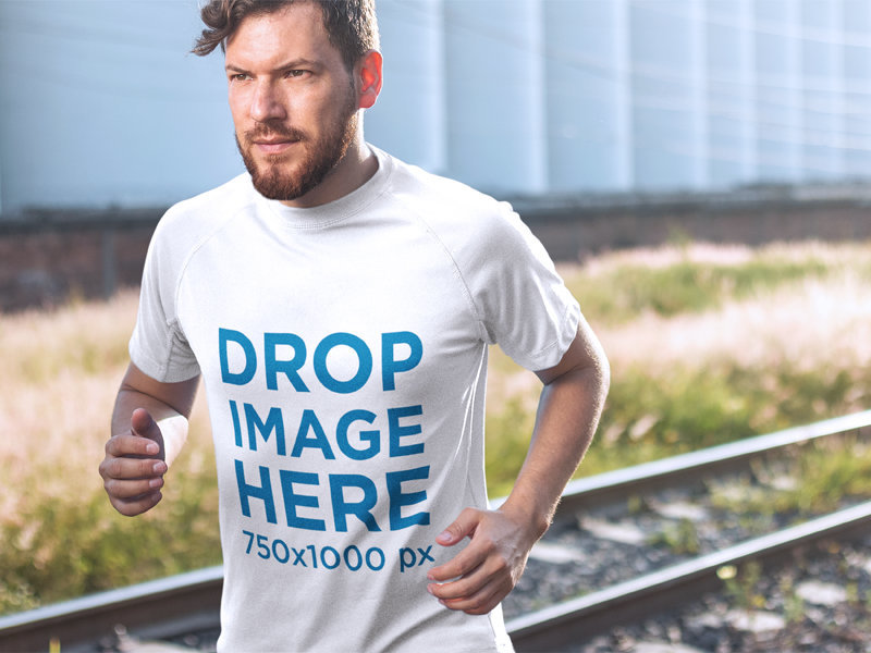 Placeit - Sports T-Shirt Mockup of a Man Running Near Some Train Tracks