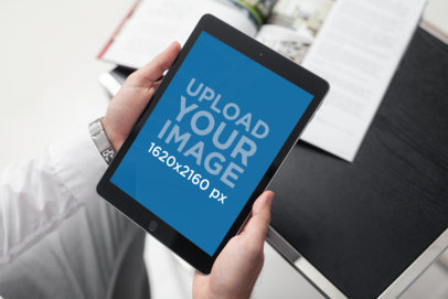 Placeit - Mockup of a Man Holding an iPad in Portrait Position