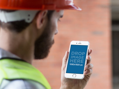 Placeit - Mockup of a Construction Man Using His iPhone in Portrait Mode