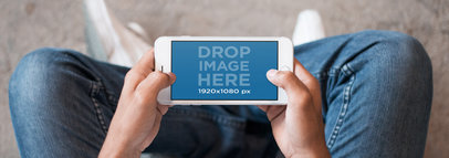 Placeit - Mockup of Man Sitting on The Floor While Holding an iPhone in ...