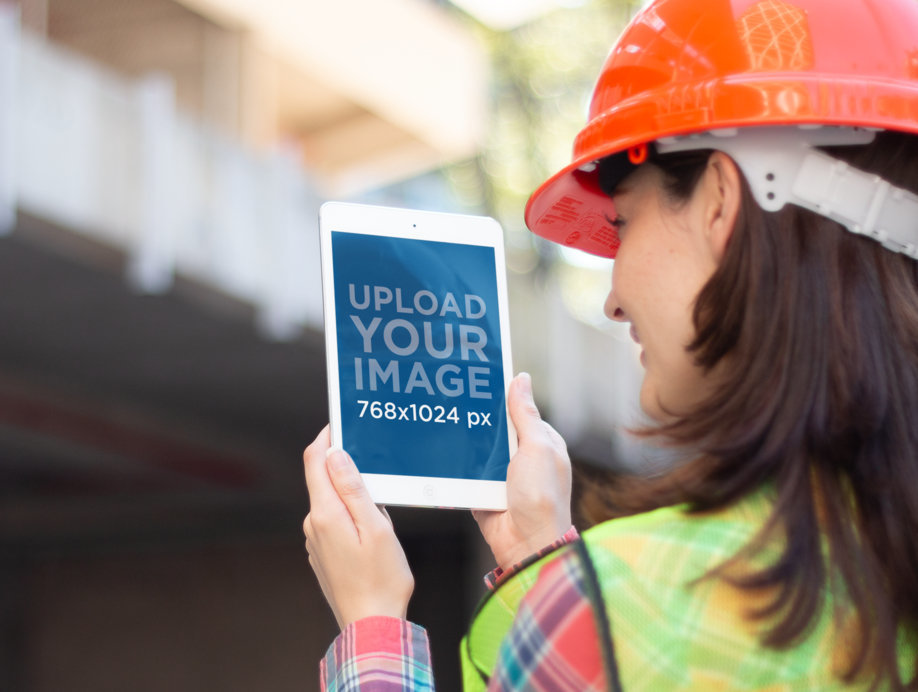 Placeit - Mockup of a Woman Holding an iPad at a Construction Site