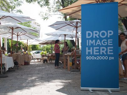 Placeit - Roll-Up Banner Mockup at an Outdoor Bazar