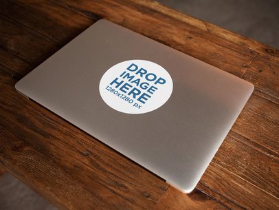 Placeit - Sticker on a Closed MacBook Over a Wooden Surface Template